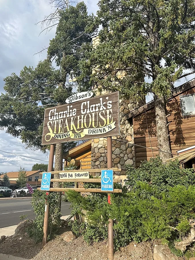 A rustic log cabin meets gourmet paradise! Charlie Clark's Steakhouse beckons with its weathered sign and promise of mouthwatering delights. Who knew heaven had a parking lot?