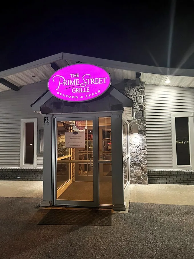 The neon pink sign glows like a beacon in the night, promising culinary treasures inside this unassuming roadside building.