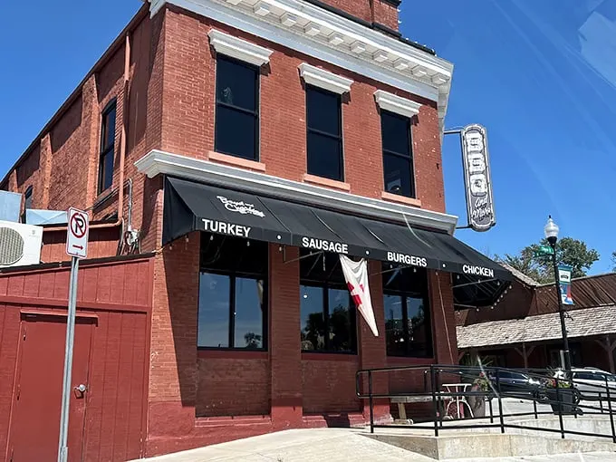 The historic brick building housing Boyd & Charlie's stands like a time capsule of Americana, complete with vintage car and promises of smoky delights within.