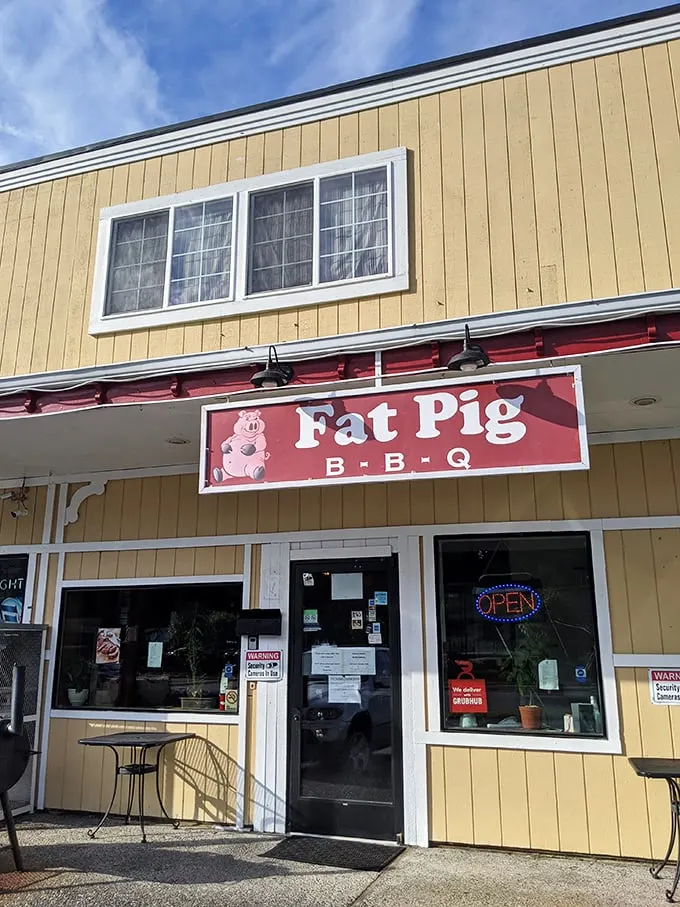 Welcome to BBQ paradise! Fat Pig BBQ's cheerful yellow exterior and pink sign promise smoky delights that'll make your taste buds do a happy dance.