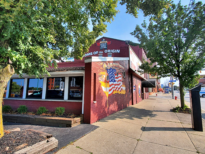 The unassuming red brick exterior of Anchor Bar proudly declares itself "Home of the Origin" – where culinary history was made one fateful night in 1964.