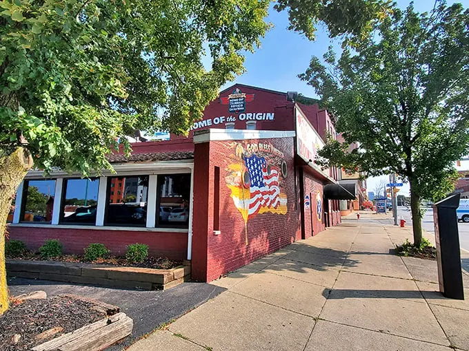 The unassuming red brick exterior of Anchor Bar proudly declares itself "Home of the Origin" – where culinary history was made one fateful night in 1964.