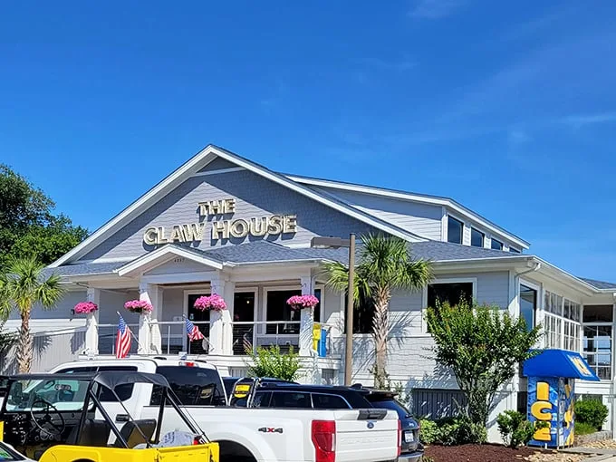Welcome to seafood paradise! The Claw House stands proud, a beacon of deliciousness with its crisp white exterior and inviting palm trees.