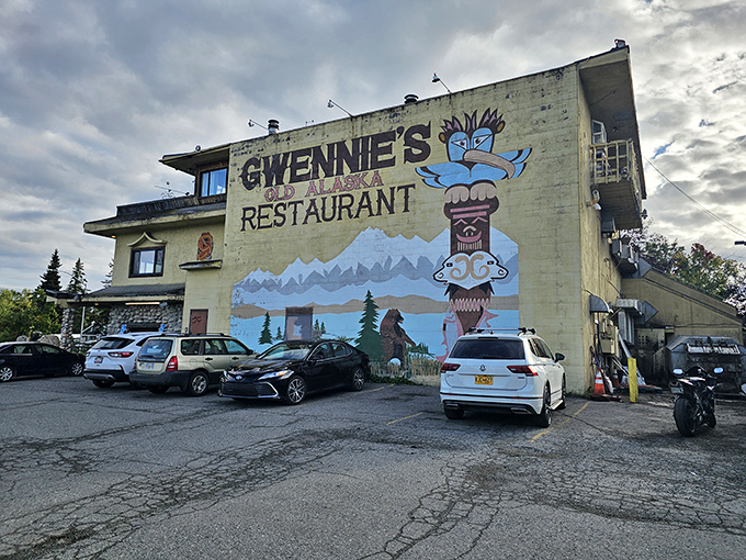 The pale yellow exterior of Gwennie's stands like a cheerful sentinel against Alaska's often-gray skies, complete with iconic totem pole mural.