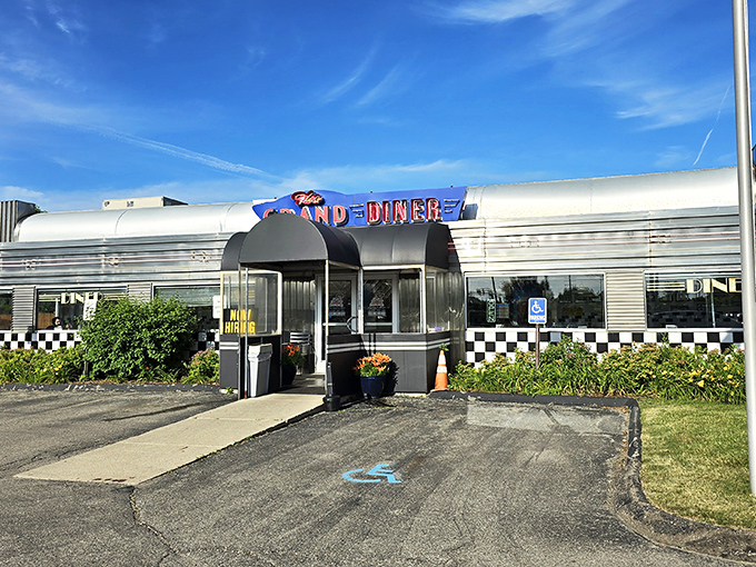 The gleaming stainless steel exterior of The Grand Diner stands like a time machine to the golden age of roadside Americana. Those neon letters promise more than food—they promise nostalgia.