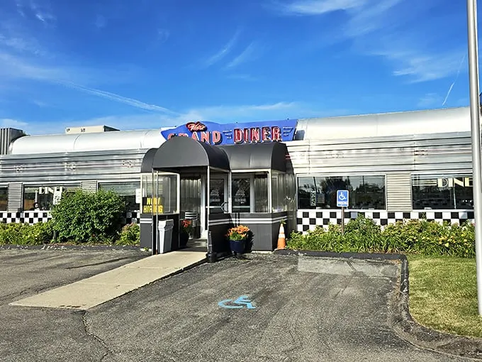 The gleaming stainless steel exterior of The Grand Diner stands like a time machine to the golden age of roadside Americana. Those neon letters promise more than food—they promise nostalgia.