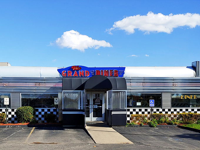 The gleaming stainless steel exterior of The Grand Diner stands like a time machine to the golden age of roadside Americana. Those neon letters promise more than food—they promise nostalgia.