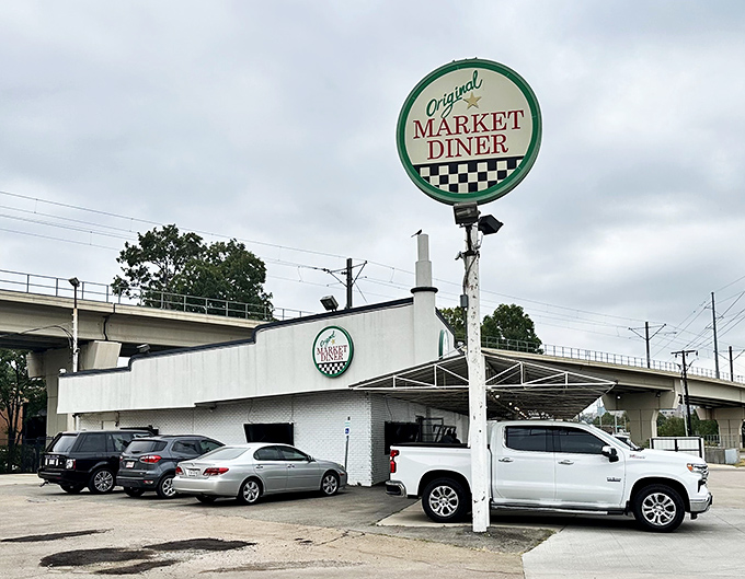 The iconic circular sign of Original Market Diner stands tall against the Dallas sky, a beacon for breakfast enthusiasts since the 1950s.
