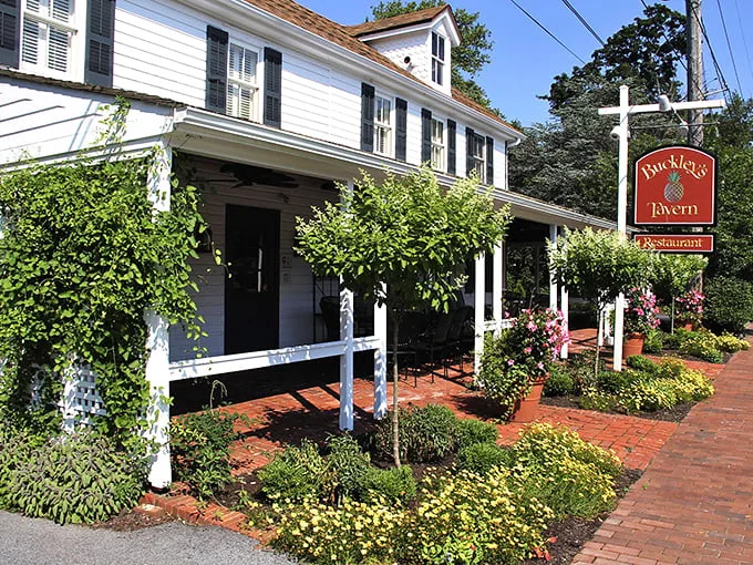 A storybook come to life! Buckley's Tavern's charming exterior beckons with its white clapboard siding, inviting porch, and lush gardens. It's the culinary equivalent of a warm hug.