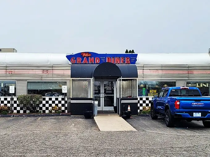 The gleaming stainless steel exterior of The Grand Diner stands like a time machine to the golden age of roadside Americana. Those neon letters promise more than food—they promise nostalgia.