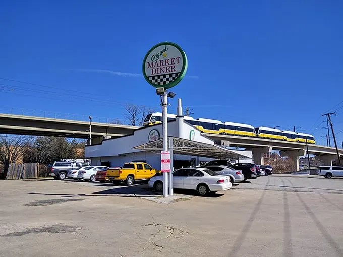 The iconic circular sign of Original Market Diner stands tall against the Dallas sky, a beacon for breakfast enthusiasts since the 1950s.