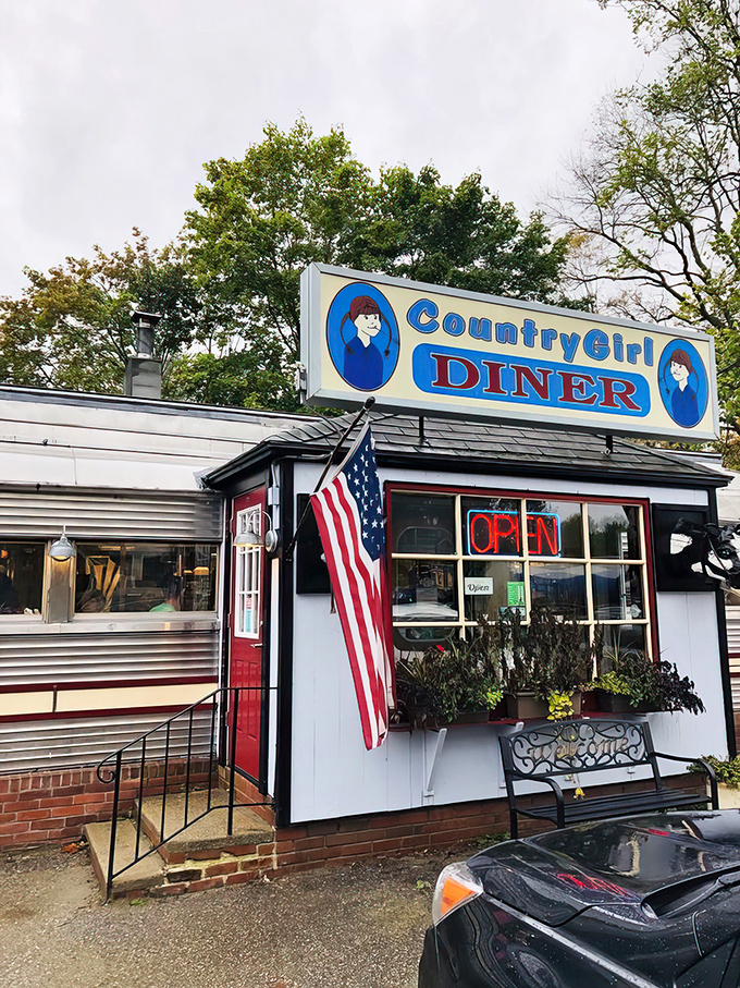 The classic silver diner car with its bright blue sign stands like a time capsule on Route 103, promising comfort food and conversations that matter.