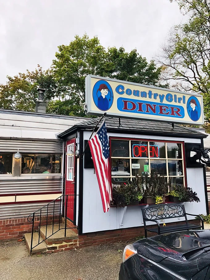 The classic silver diner car with its bright blue sign stands like a time capsule on Route 103, promising comfort food and conversations that matter.