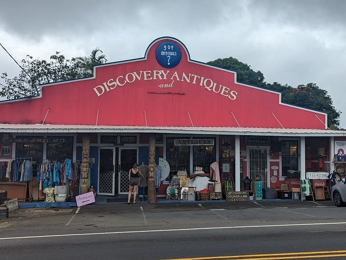 A red beacon of nostalgia! Discovery Antiques stands out like a Hawaiian shirt at a black-tie event, promising treasures and ice cream.