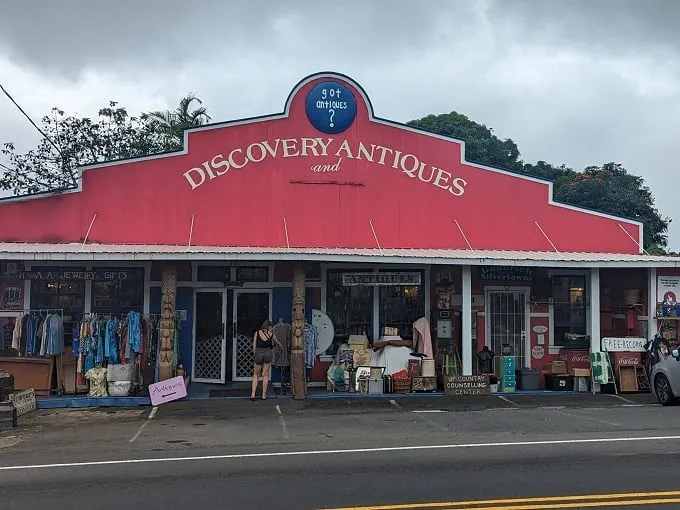 A red beacon of nostalgia! Discovery Antiques stands out like a Hawaiian shirt at a black-tie event, promising treasures and ice cream.