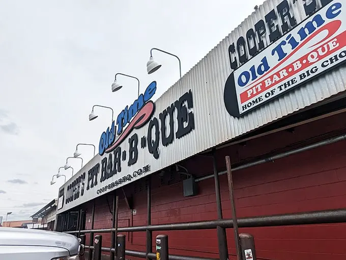 Welcome to meat paradise! Cooper's Old Time Pit Bar-B-Que stands proud, its red-trimmed exterior promising smoky delights that'll make your taste buds do a happy dance.