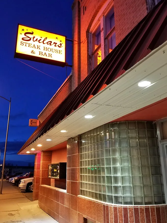 A red-brick beacon of culinary delight! Svilar's Steak House & Bar stands proud, its sign is a siren call to hungry travelers and locals alike.