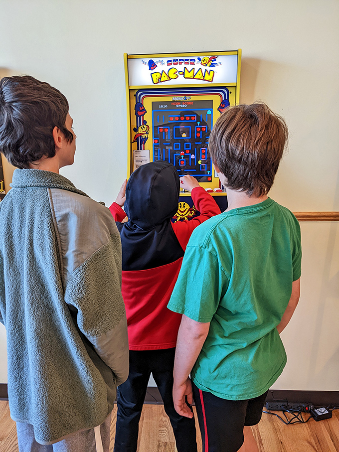 The Super Pac-Man arcade machine—where kids build hand-eye coordination while parents finish their coffee in what can only be described as a win-win situation.