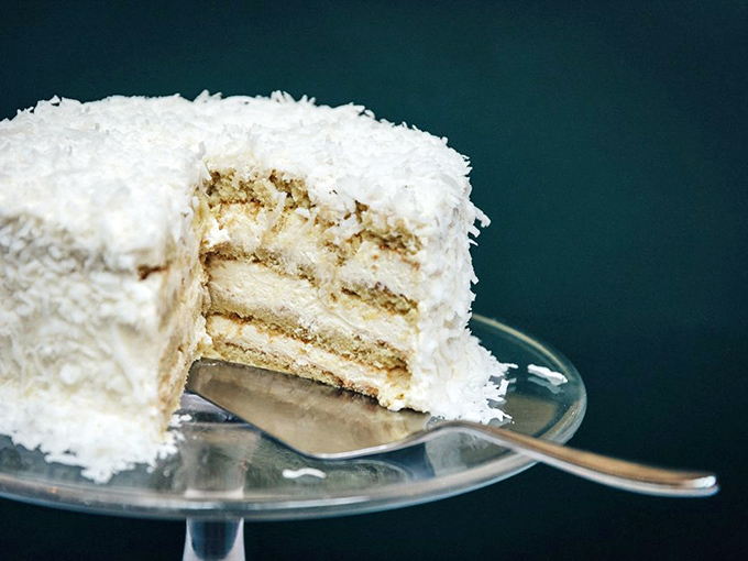 This coconut cake doesn't just end a meal—it provides a legitimate reason to skip the next one. Worth every calorie-laden forkful.