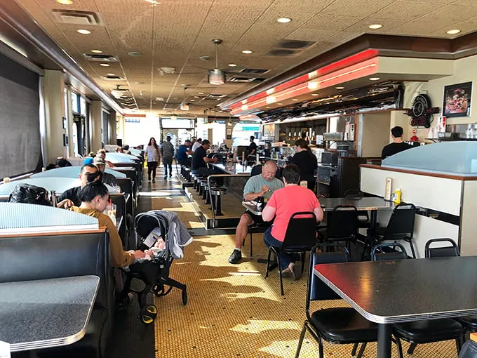 A slice of Anchorage life, served hot and fresh. These diners aren't just eating – they're participating in a time-honored ritual of community and comfort.