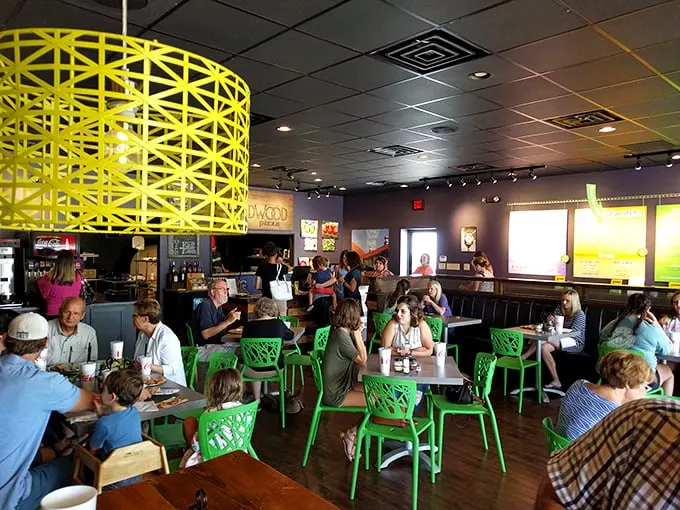Happy diners, lost in pizza bliss. It's like watching a room full of food critics suddenly remember why they fell in love with eating in the first place.