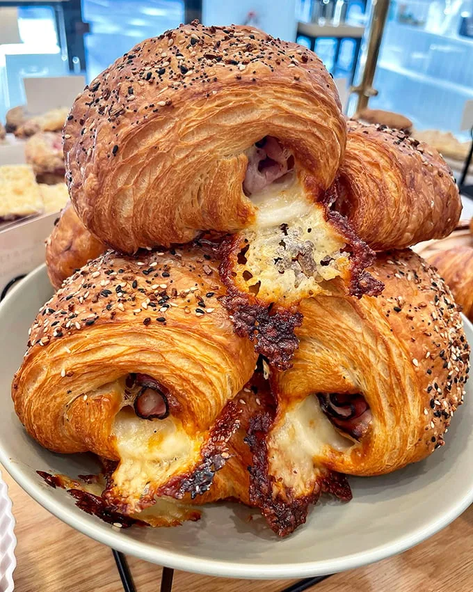 These aren't just croissants, they're buttery time machines. One bite and you're transported to a Parisian café, beret not included.