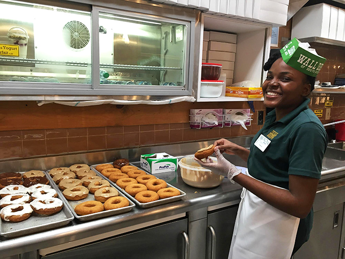 Smile! You're about to experience donut nirvana. This Wall Drug staffer is serving up happiness, one perfectly glazed ring at a time.