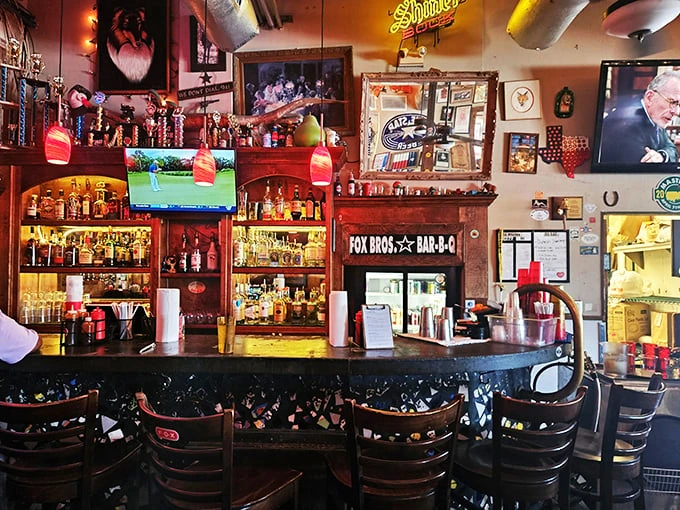 The bar at Fox Bros. isn't just serving drinks—it's serving community. Where else can you watch the game surrounded by barbecue trophies?