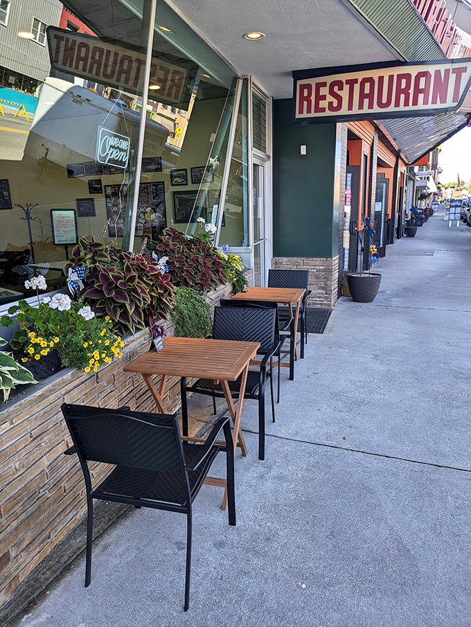 Sidewalk seating surrounded by cheerful flowers—because sometimes breakfast tastes even better with a side of fresh air and people-watching.