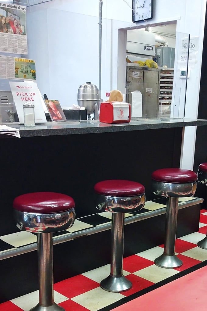 Classic diner stools where calories don't count and coffee refills flow freely. The perfect perch for watching donut theater unfold.