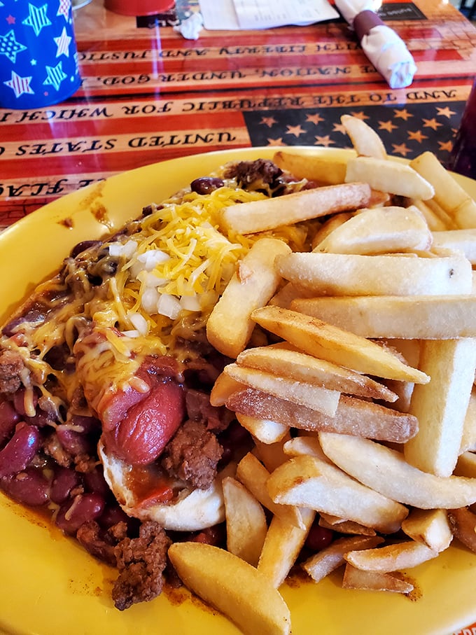 A chili dog that demands both napkins and respect, surrounded by fries that somehow manage to be both supporting actors and co-stars.