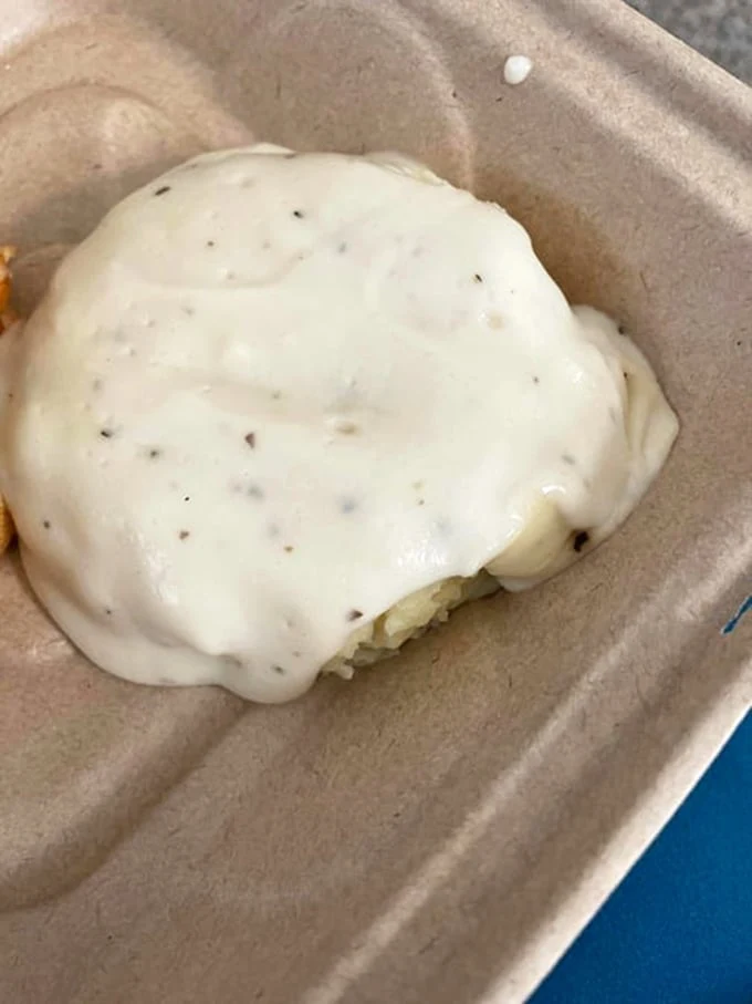 This isn't just mashed potatoes—it's a cloud of comfort nestled in a humble takeout container. Proof that true luxury doesn't require fancy packaging.