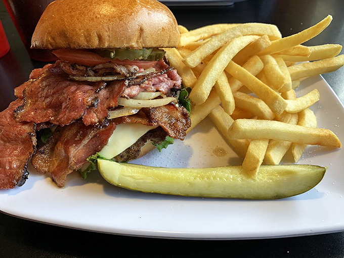 A burger that requires both hands, strategic planning, and possibly a nap afterward. That pickle isn't a garnish – it's essential structural support.
