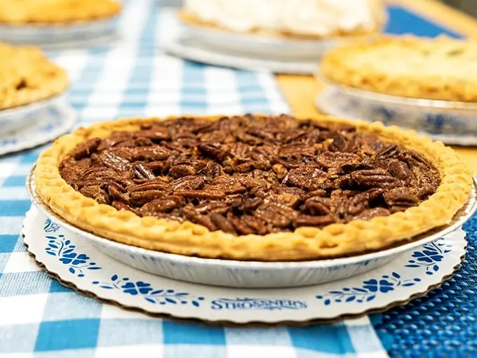 Pecan pie perfection on a blue gingham altar. It's like the state fair blue ribbon winner decided to pay us a house call.