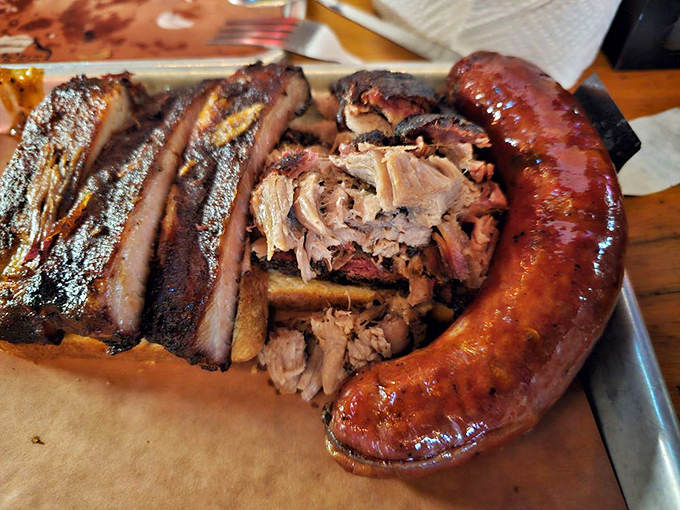 The barbecue trinity: ribs, pulled pork, and that jalapeño cheddar sausage. This plate isn't a meal—it's a religious experience.