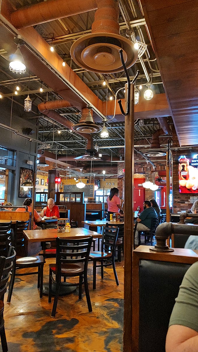 Industrial pipes overhead and warm lighting create the perfect backdrop for conversations that last longer than the food on your plate.
