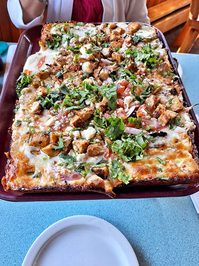 This isn't just pizza—it's a rectangular declaration of love topped with blackened chicken and enough fresh herbs to make you feel virtuous.