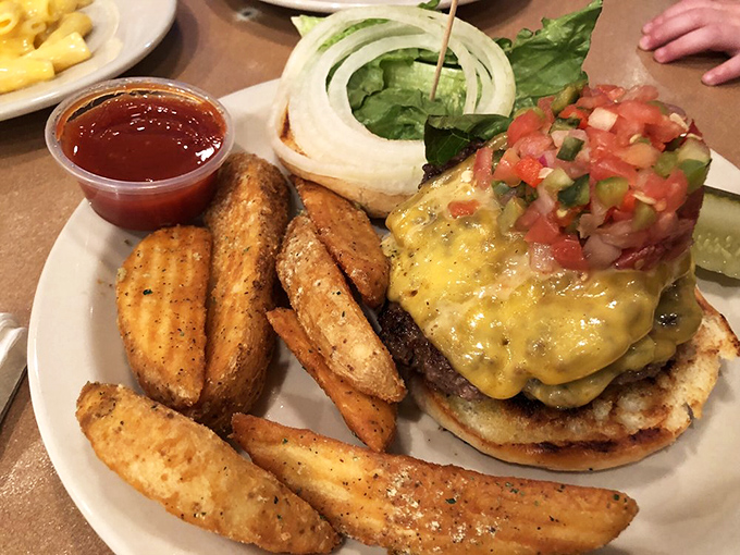 This isn't just a burger—it's a towering achievement of beef, cheese, and fresh pico de gallo that requires both hands and a strategic approach.