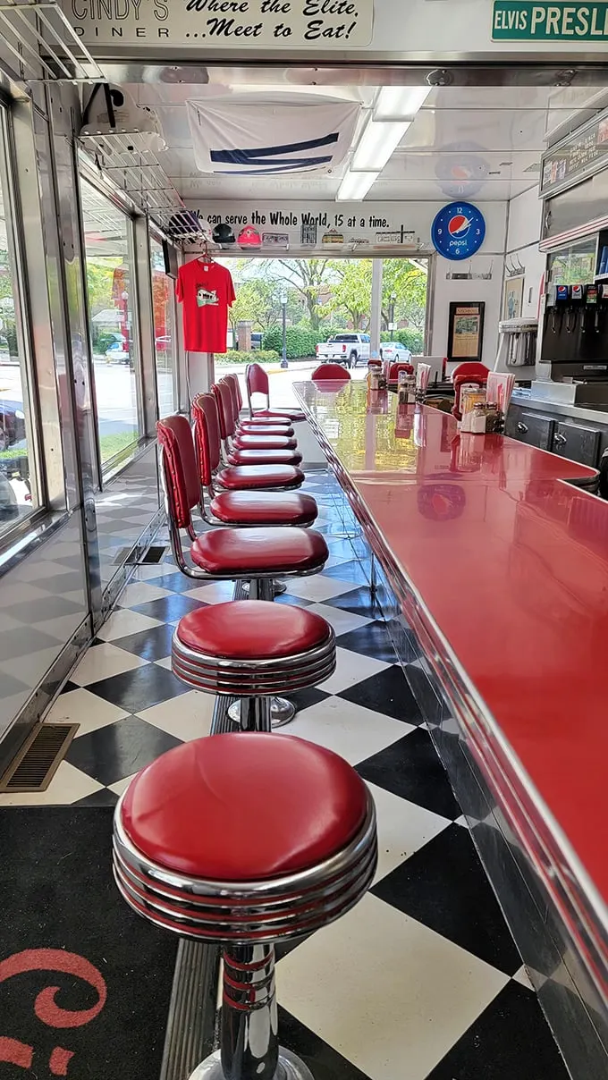 Those cherry-red stools aren't just seating—they're front-row tickets to the best breakfast show in Indiana. Note the sign: "Where the Elite Meet to Eat!"