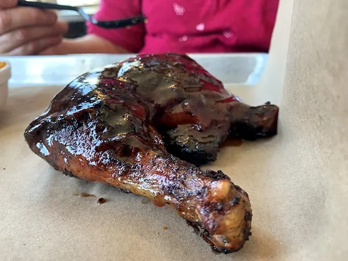 Behold, the BBQ chicken that launched a thousand napkins! This juicy, glistening quarter will have you licking your fingers with abandon.