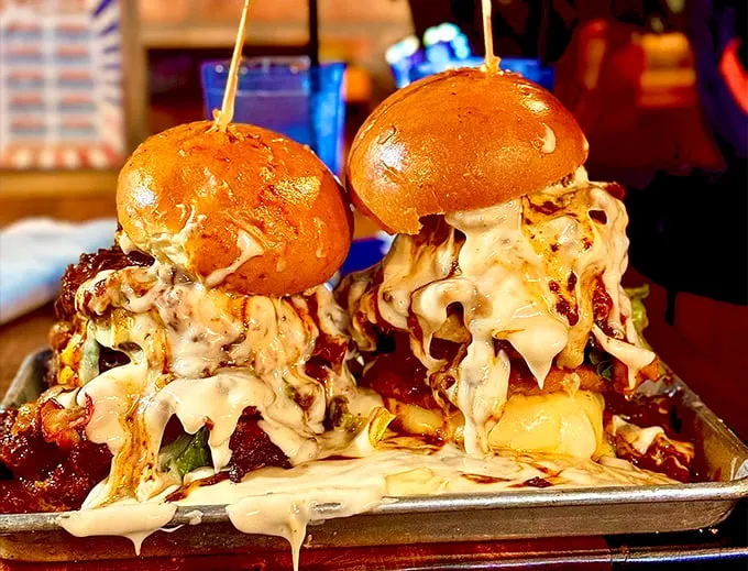 Holy moly, it's the Leaning Tower of Cheesa! These towering burgers are so loaded, they might need their own zip code.