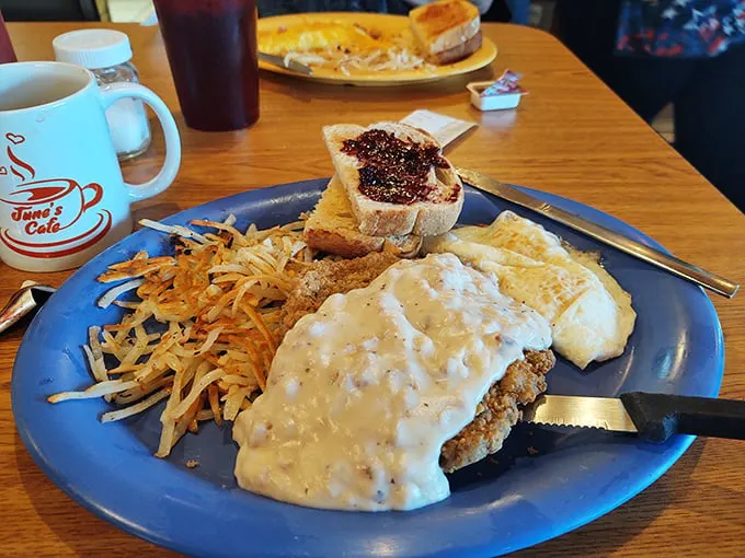 Country-fried steak swimming in creamy gravy alongside crispy hash browns – proof that sometimes the best things in life come smothered in goodness.