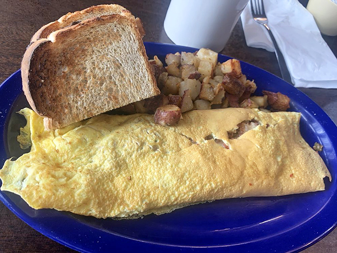 Behold, the omelet that ate Manhattan! This golden giant, flanked by crispy potatoes and hearty toast, is ready to conquer your hunger pangs.