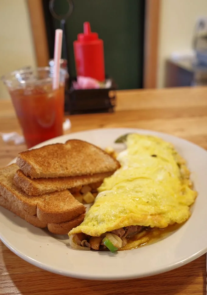 This omelet doesn't need to show off on social media; it's too busy being exactly what an omelet should be—fluffy, filled with goodness, and flanked by perfectly toasted bread.
