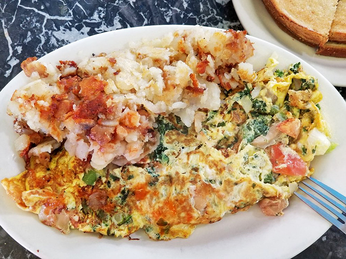Not all heroes wear capes – some come on white plates with perfectly diced vegetables folded into fluffy eggs alongside crispy home fries.