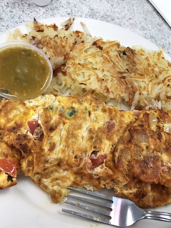 Behold the Denver omelet in its natural habitat—a perfect golden exterior giving way to a treasure trove of peppers, ham, and cheese.