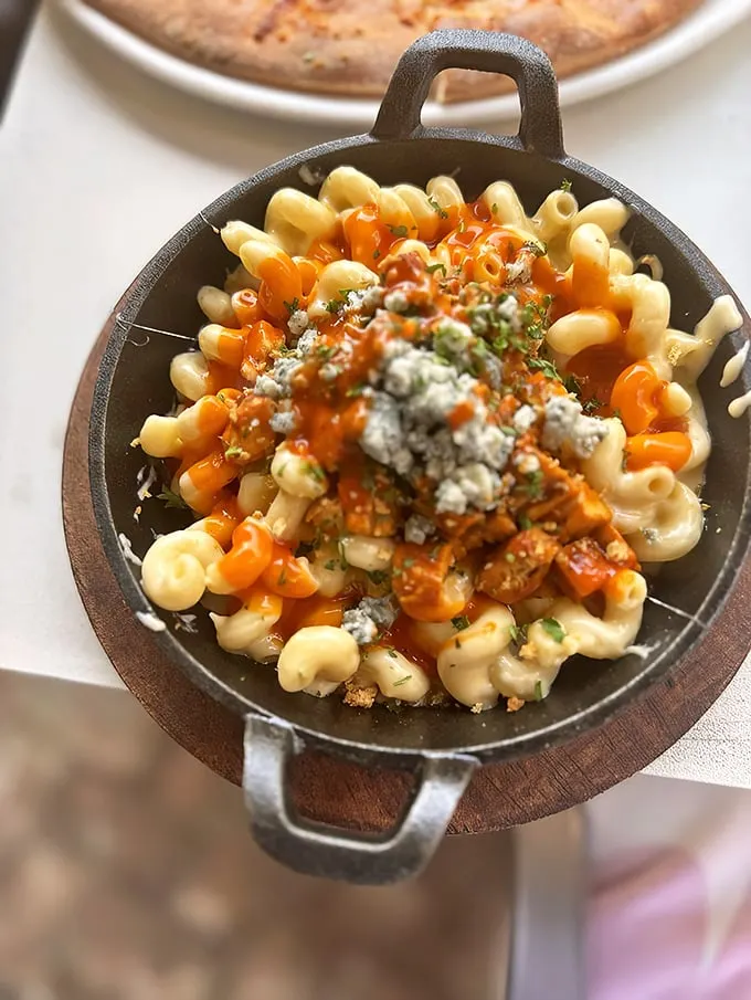 Buffalo mac and cheese topped with blue cheese crumbles – proof that sometimes the best relationships are the ones that shouldn't work but gloriously do.