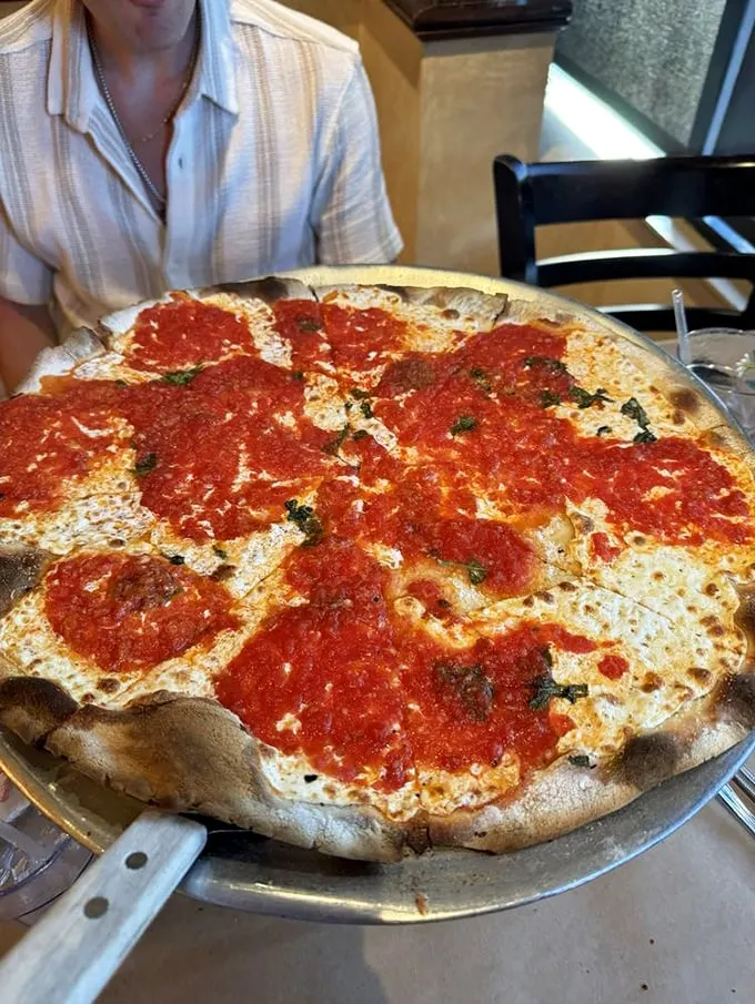 Simplicity at its finest! This Margherita pizza is so fresh, you'd think the basil was doing yoga on your plate.