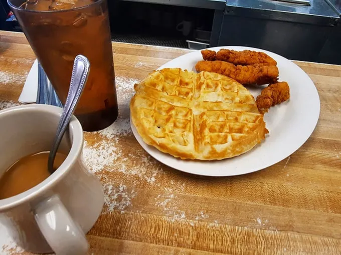 Morning fuel, diner-style. A perfectly golden waffle stands ready to soak up maple syrup, while a steaming cup of coffee promises to kickstart your day.