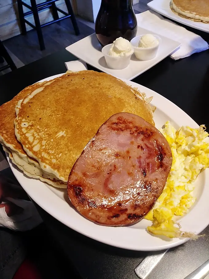 The golden ratio of breakfast perfection: pancakes the size of frisbees, ham with perfect grill marks, and eggs sunny enough to brighten your day.